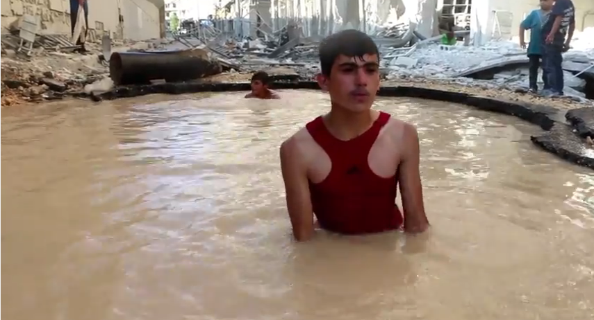 Syria bomb crater swimming pool: Kids make do.