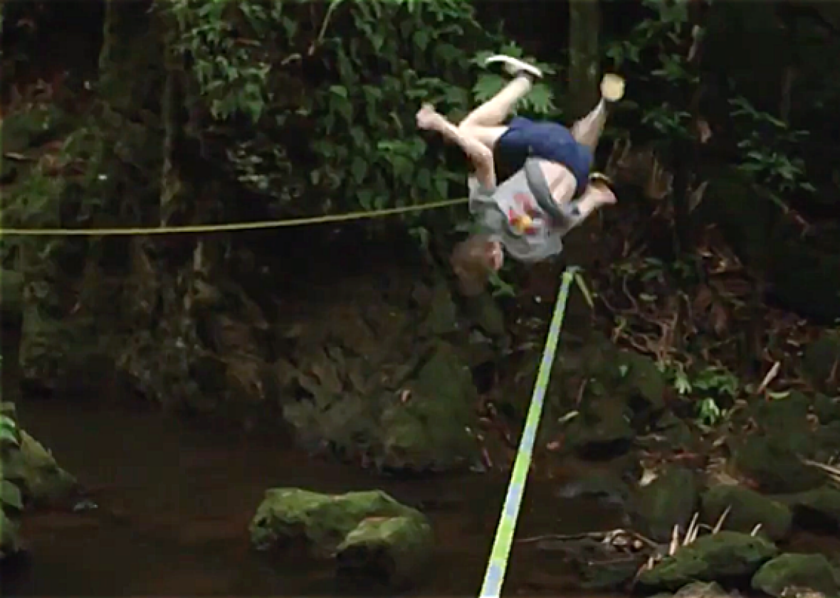 Fearless slackliner bounces up a slackladder over a Hawaiian stream ...