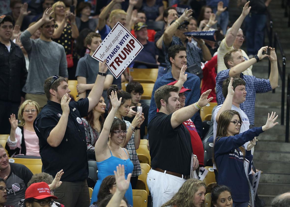 Trump supporters raise right hands to pledge support to Donald Trump.