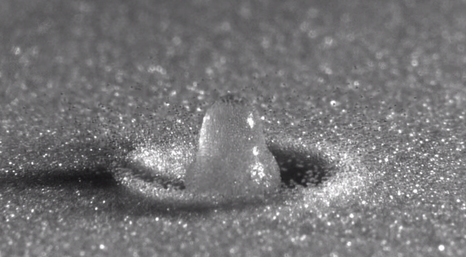 Raindrop slow-motion video: Water hitting sand looks like asteroid impacts.